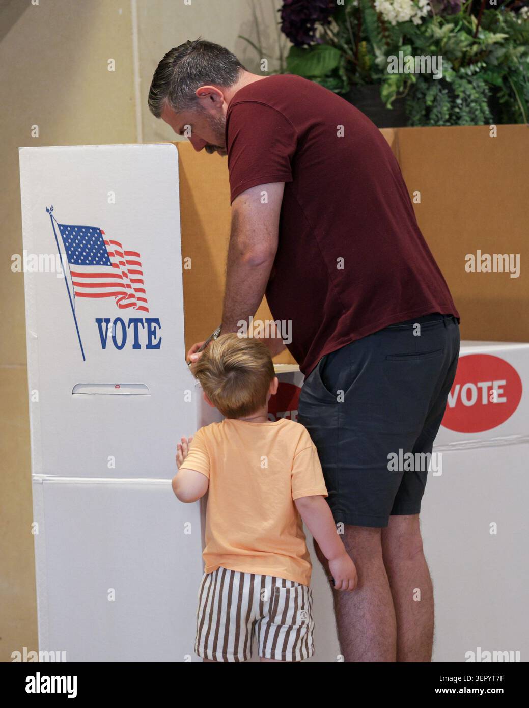 A child watches a voter mark a ballot at a polling location inside St ...
