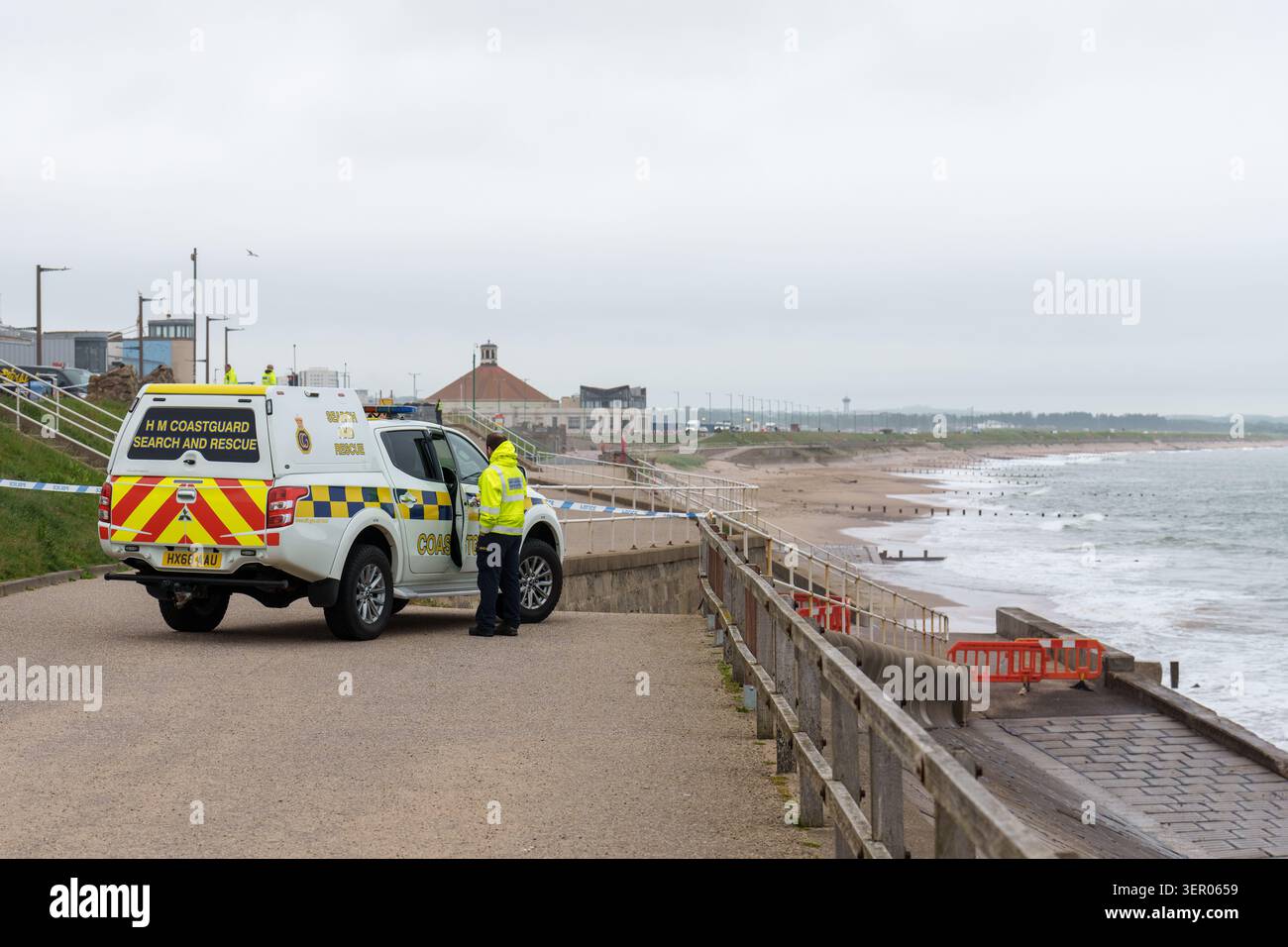 Coastguard vehicle and officer stand on Aberdeen Beach Esplanade. A ...
