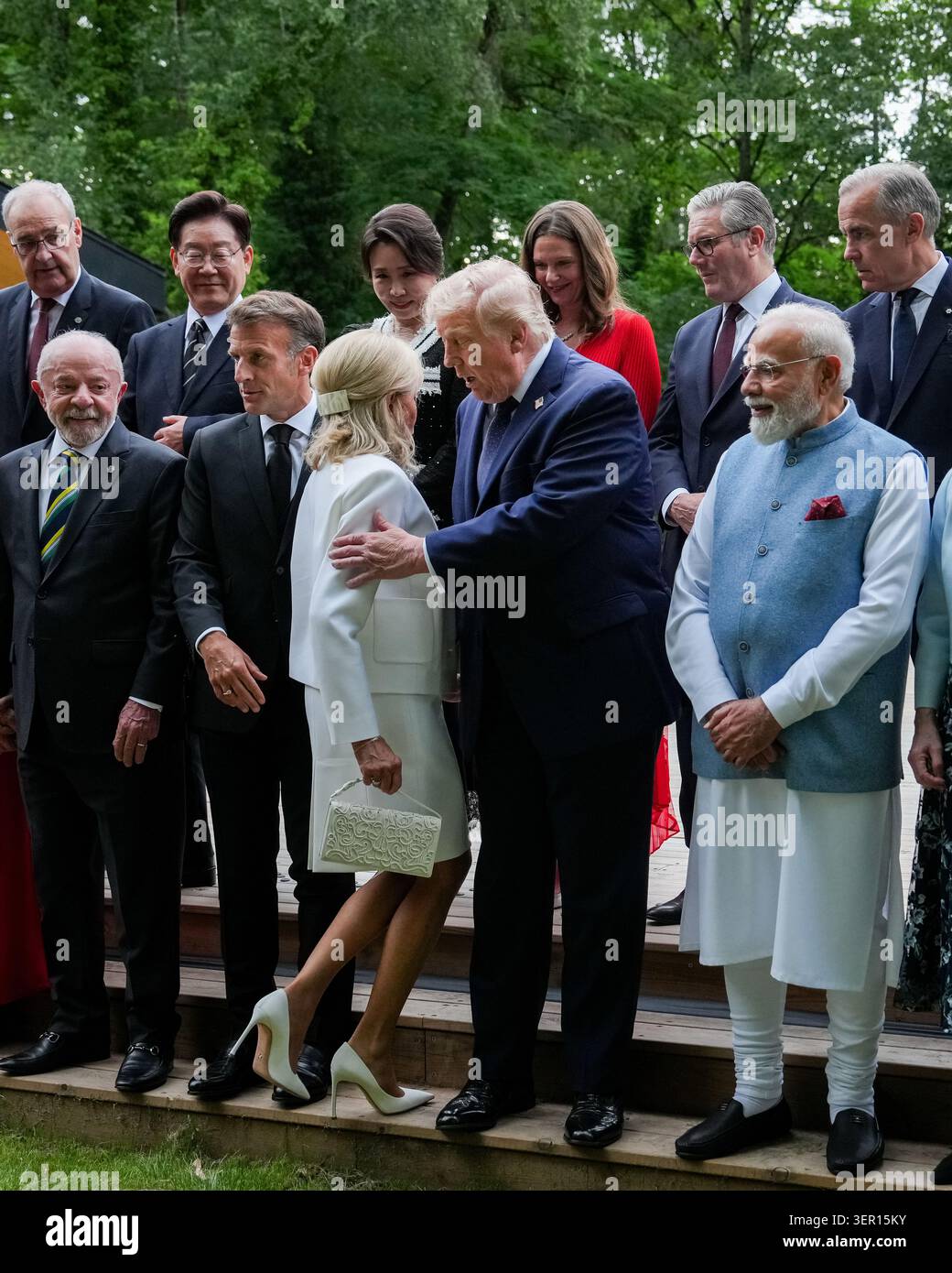 President Donald Trump helps France's first lady Brigitte Macron up a ...