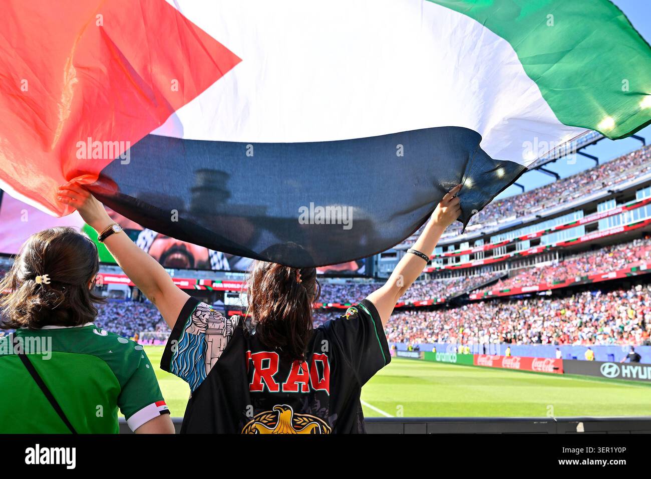 A fan holds up an Iraqi flag before a match between Iraq and Norway at ...
