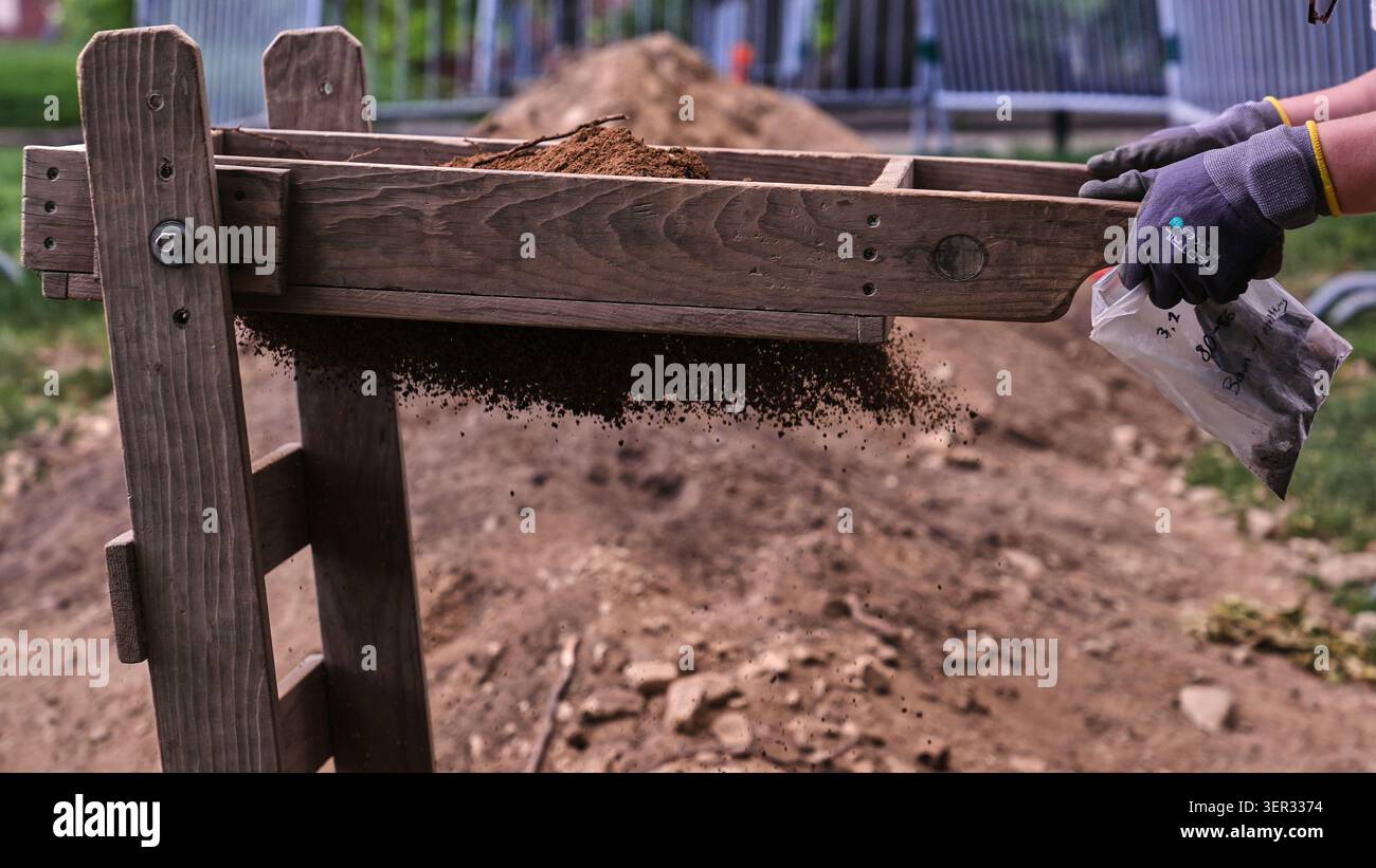 Calla Ruff, an intern from Carleton College, sifts dirt removed from an ...