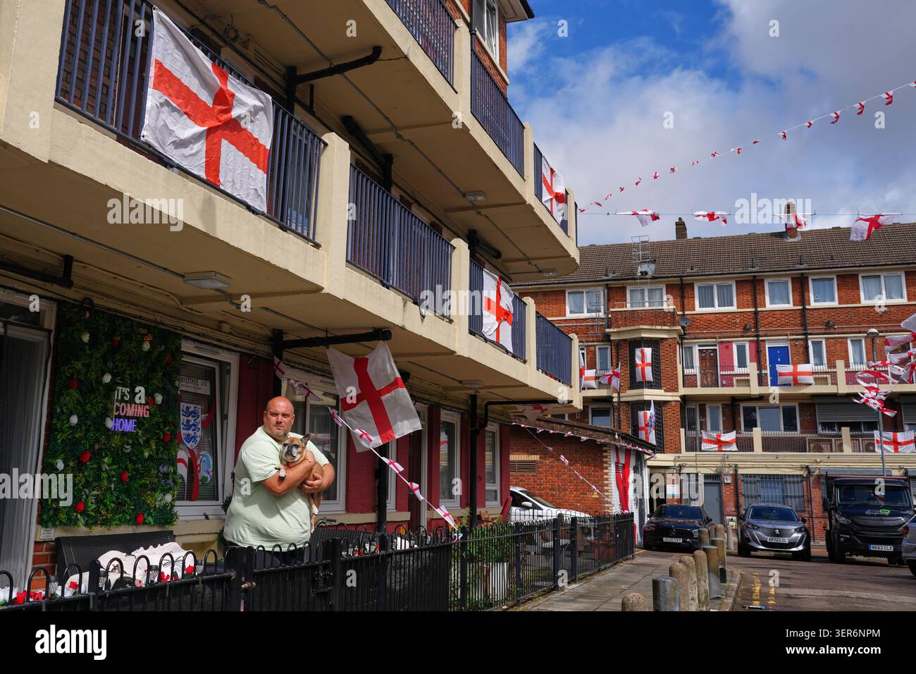 Chris Dowse hugs his dog Tinkerbell as England flags decorate Kirby ...