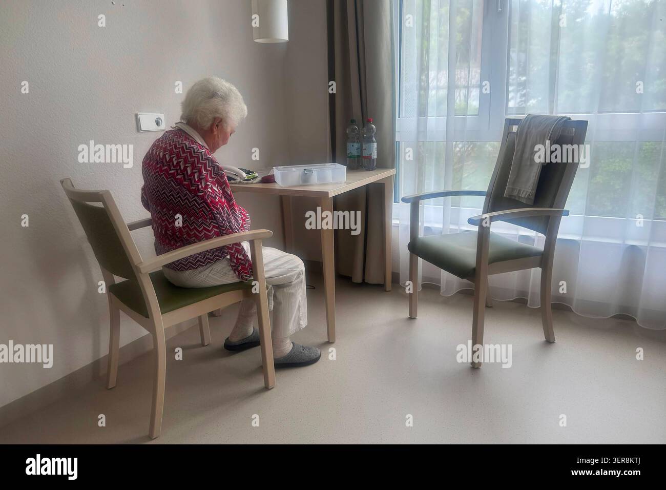 Bewohnerin,Bewohner,alte Frau sitzt allein in ihrem Zimmer in einem ...