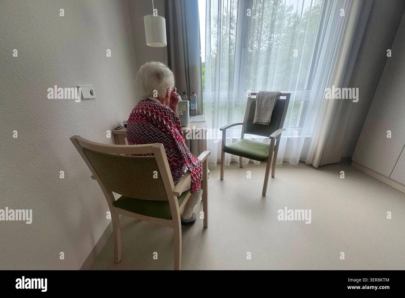 Bewohnerin,Bewohner,alte Frau sitzt allein in ihrem Zimmer in einem ...