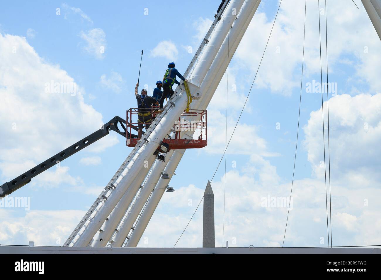 Workers secure a support leg of a 110-foot ferris wheel which is being ...