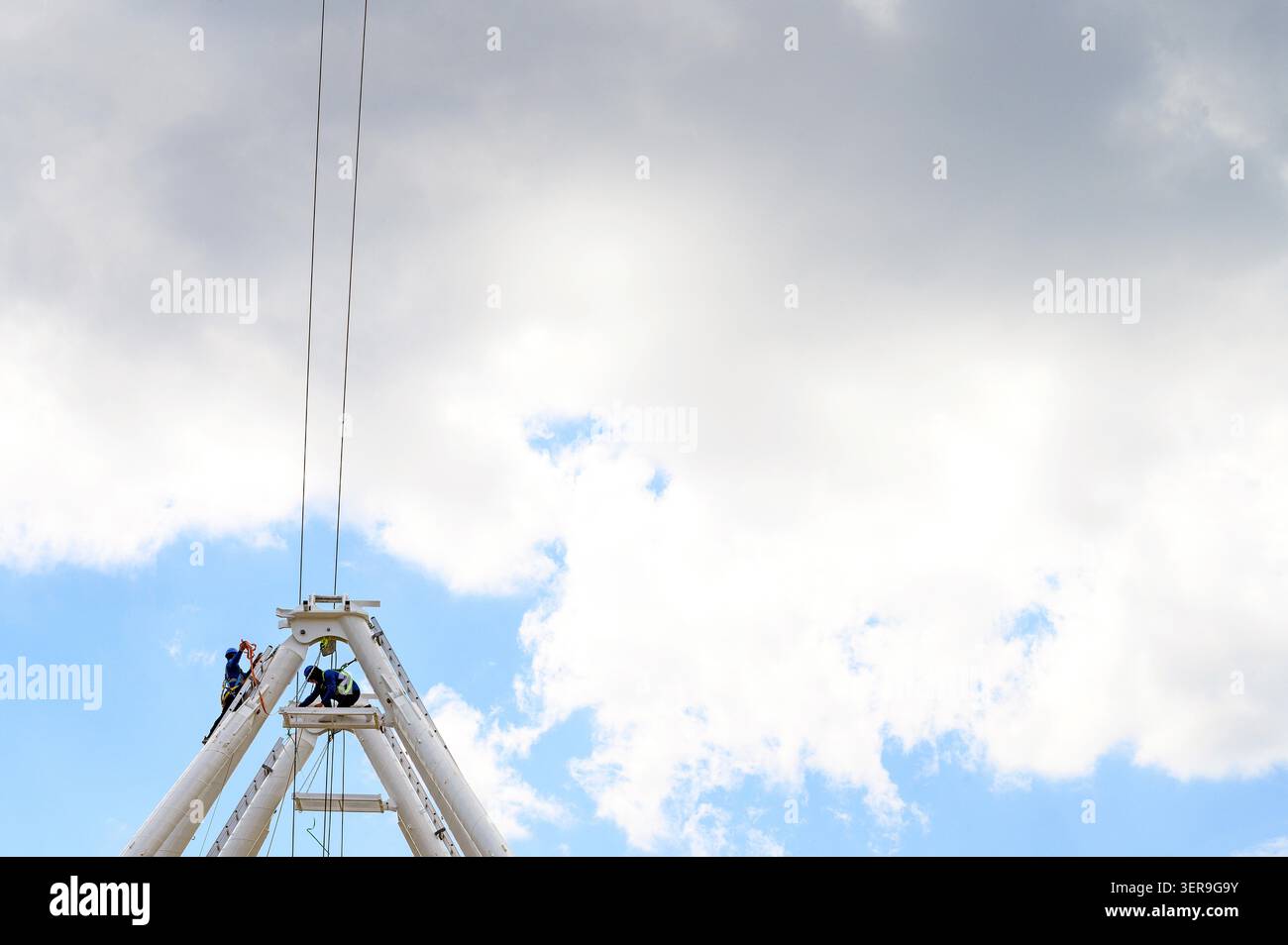 Workers secure a support leg of a 110-foot ferris wheel which is being ...
