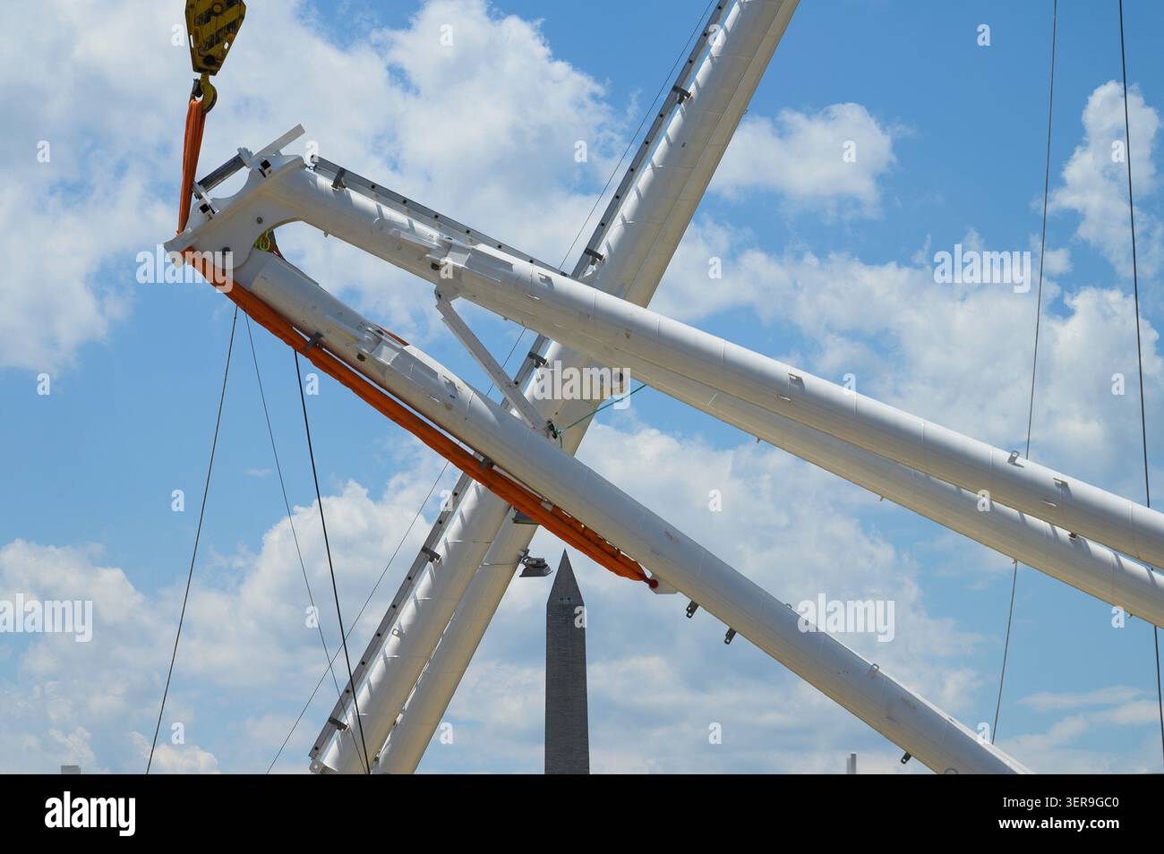 Workers secure a support leg of a 110-foot ferris wheel which is being ...
