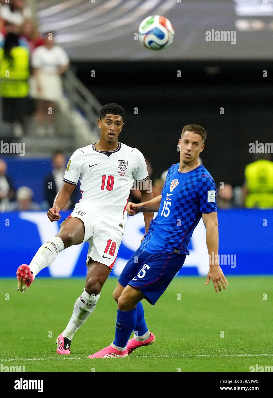 England's Jude Bellingham (left) and Croatia's Mario Pasalic in action ...