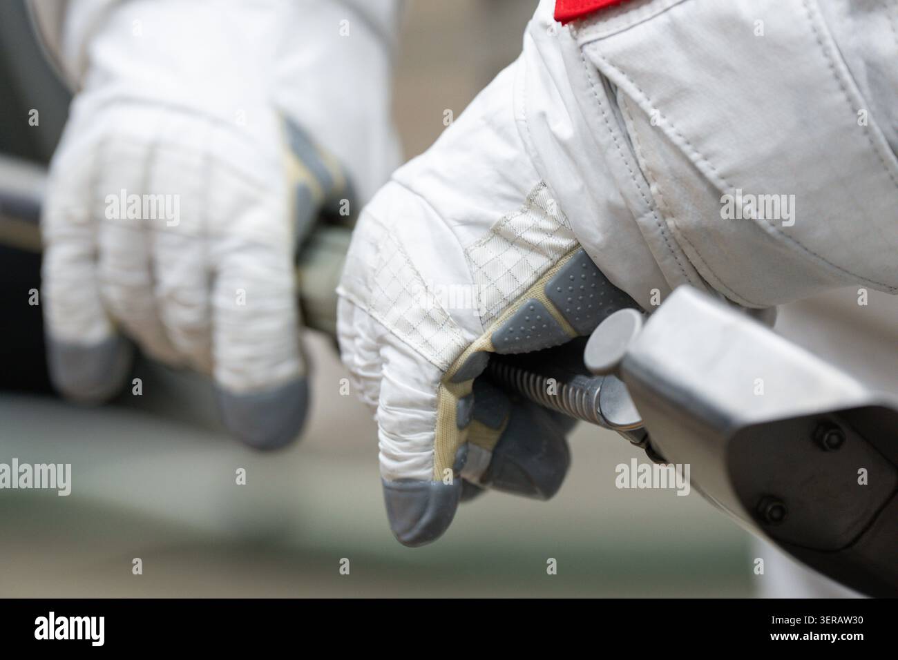 Spacesuit design engineer Travis Cooper uses a tool during a ...