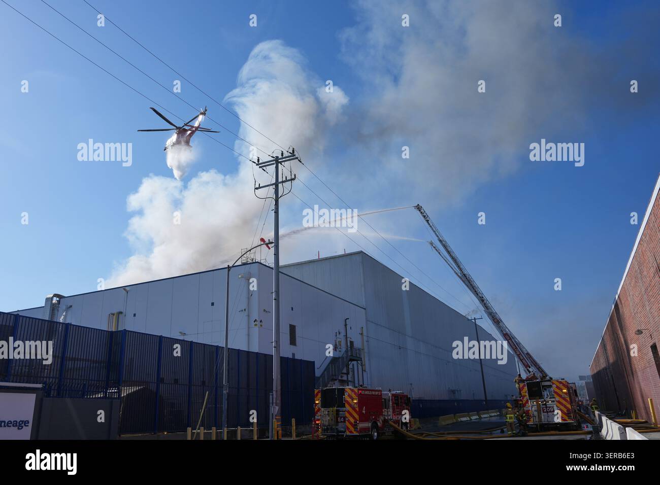 Water is dropped by helicopter at a warehouse fire in the Boyle Heights ...