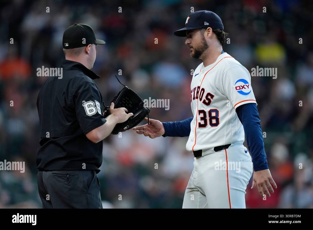 First base umpire Steven Jaschinski checks the glove of Houston Astros ...