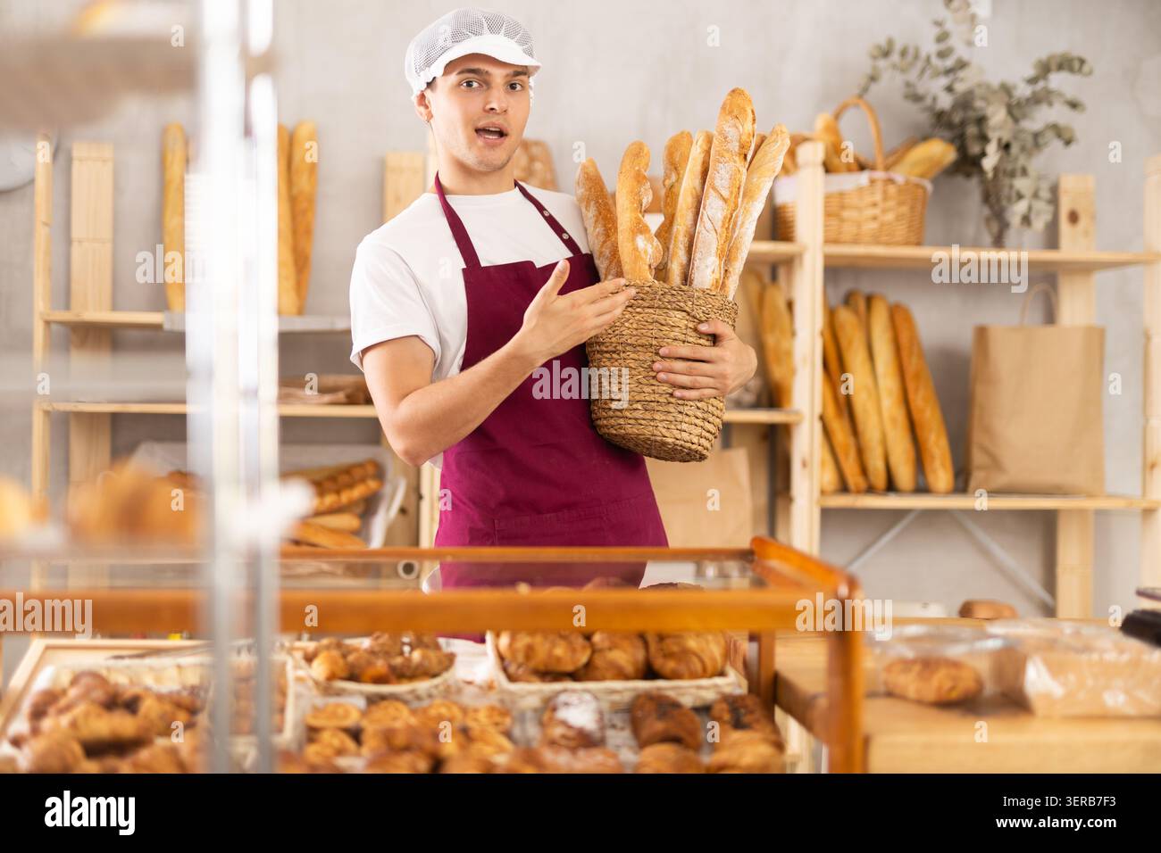 Male baker sells croissants and displays many different types of ...