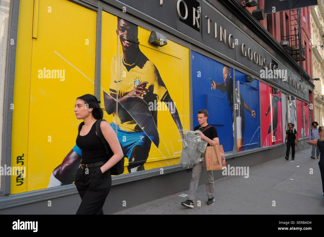 People walk past a poster of Brazilian soccer player, Vini Jr., outside ...