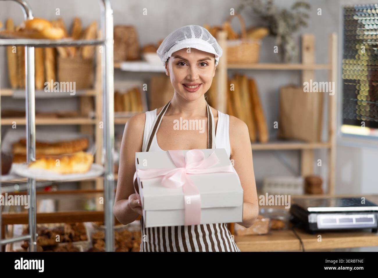 Young female seller with box of pastries Stock Photo - Alamy