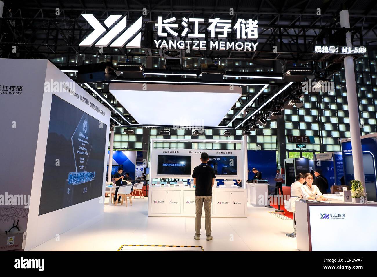 Visitors tour the Yangtze Memory Technologies booth during the China ...