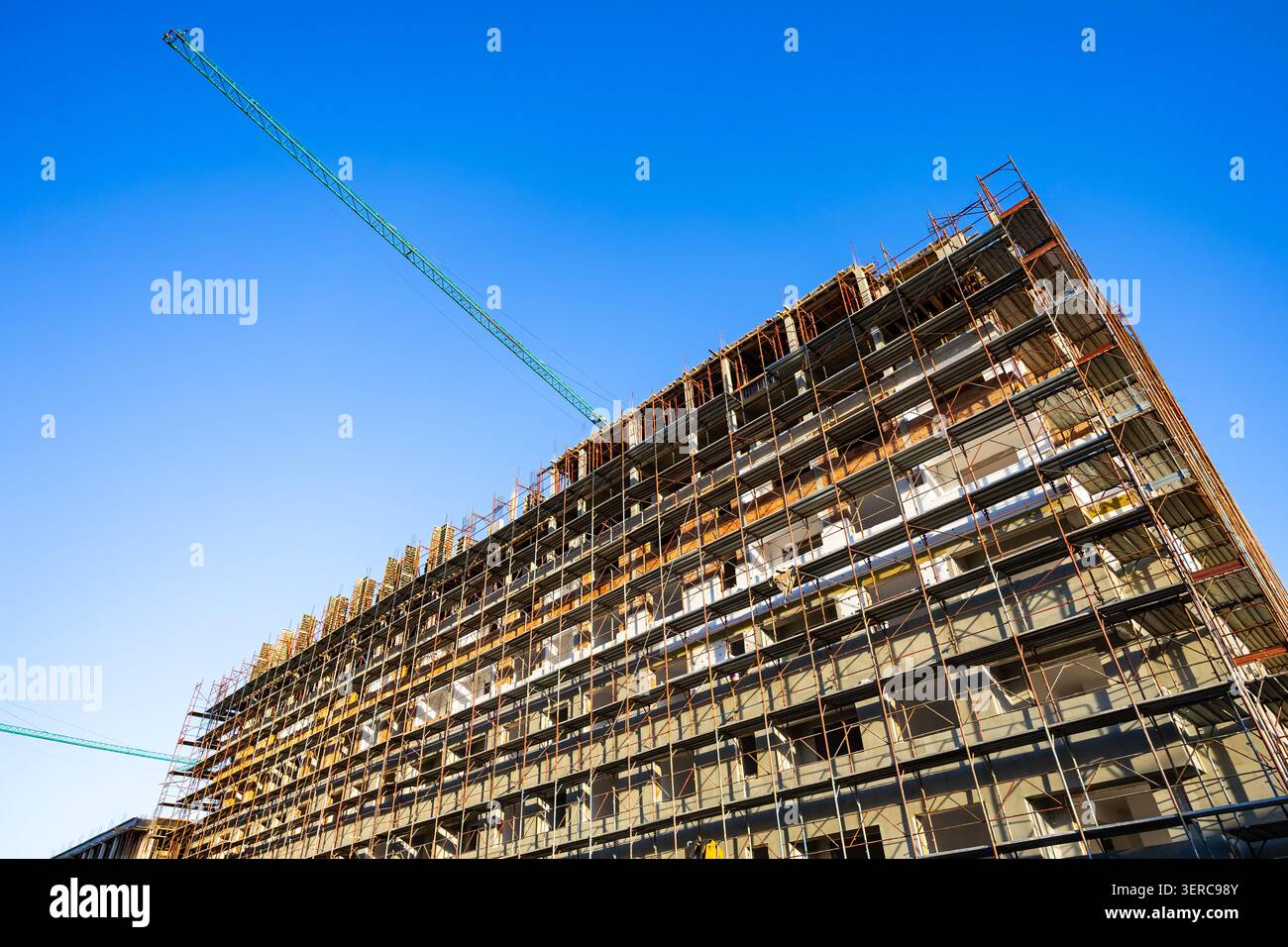 Low angle view of modern residential building under construction with ...