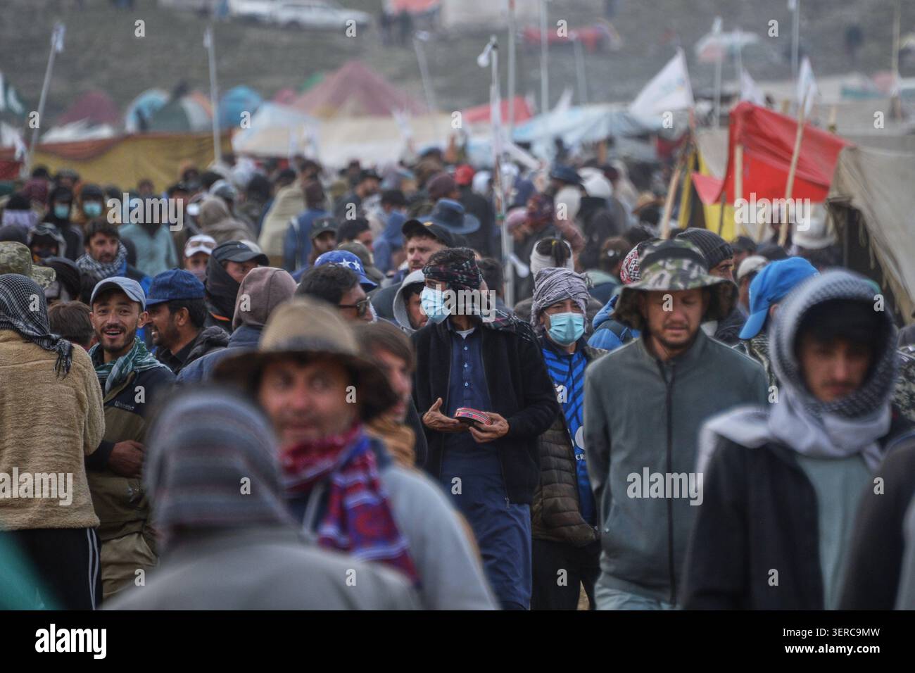 Spectators walk through a temporary tent settlement during the three ...
