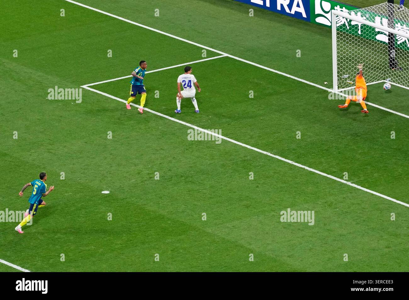 Colombia's Jaminton Campaz (21), left, scores his side's third goal ...