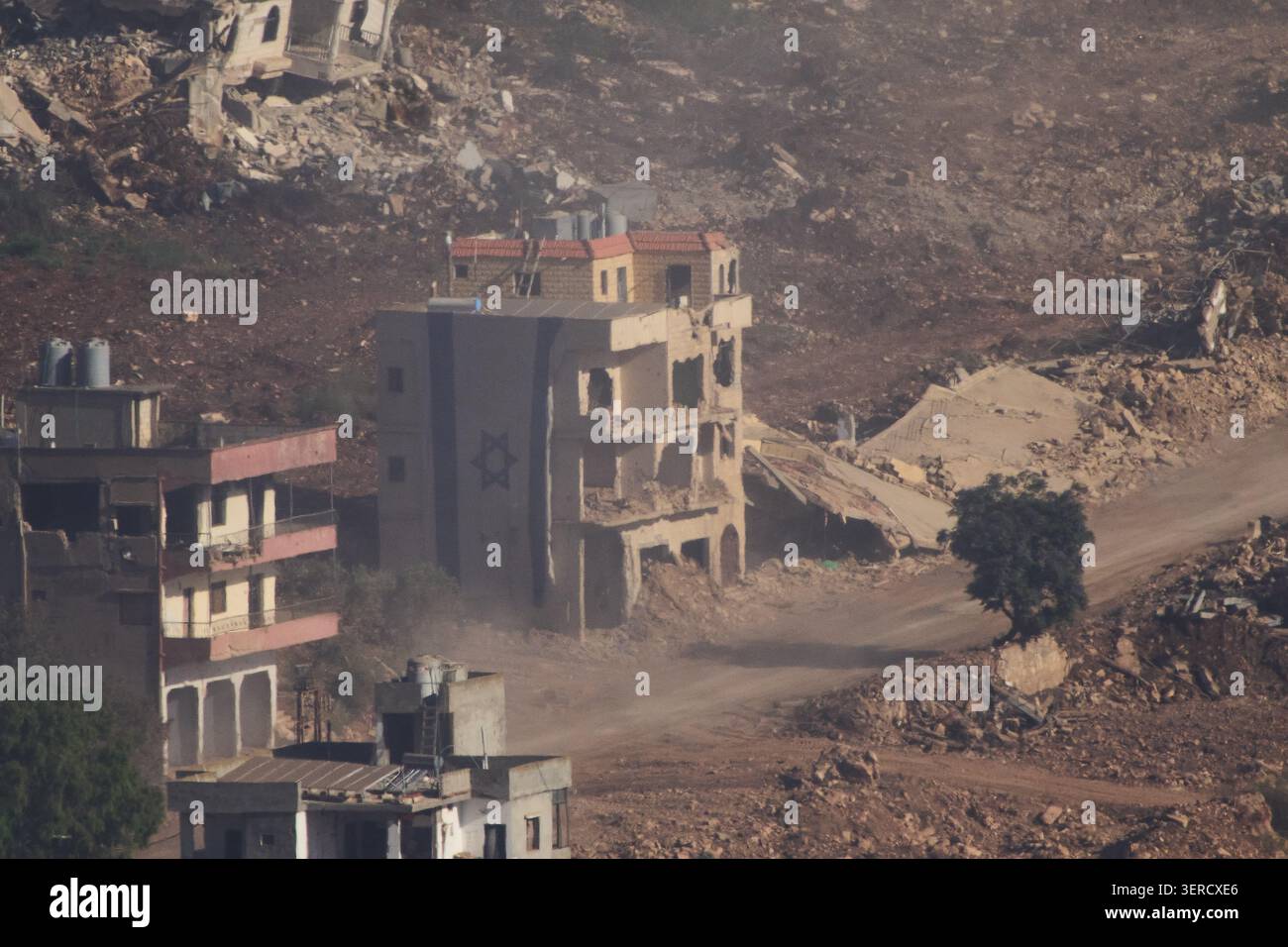 An Israeli flag covers a part of a damaged building in southern Lebanon ...