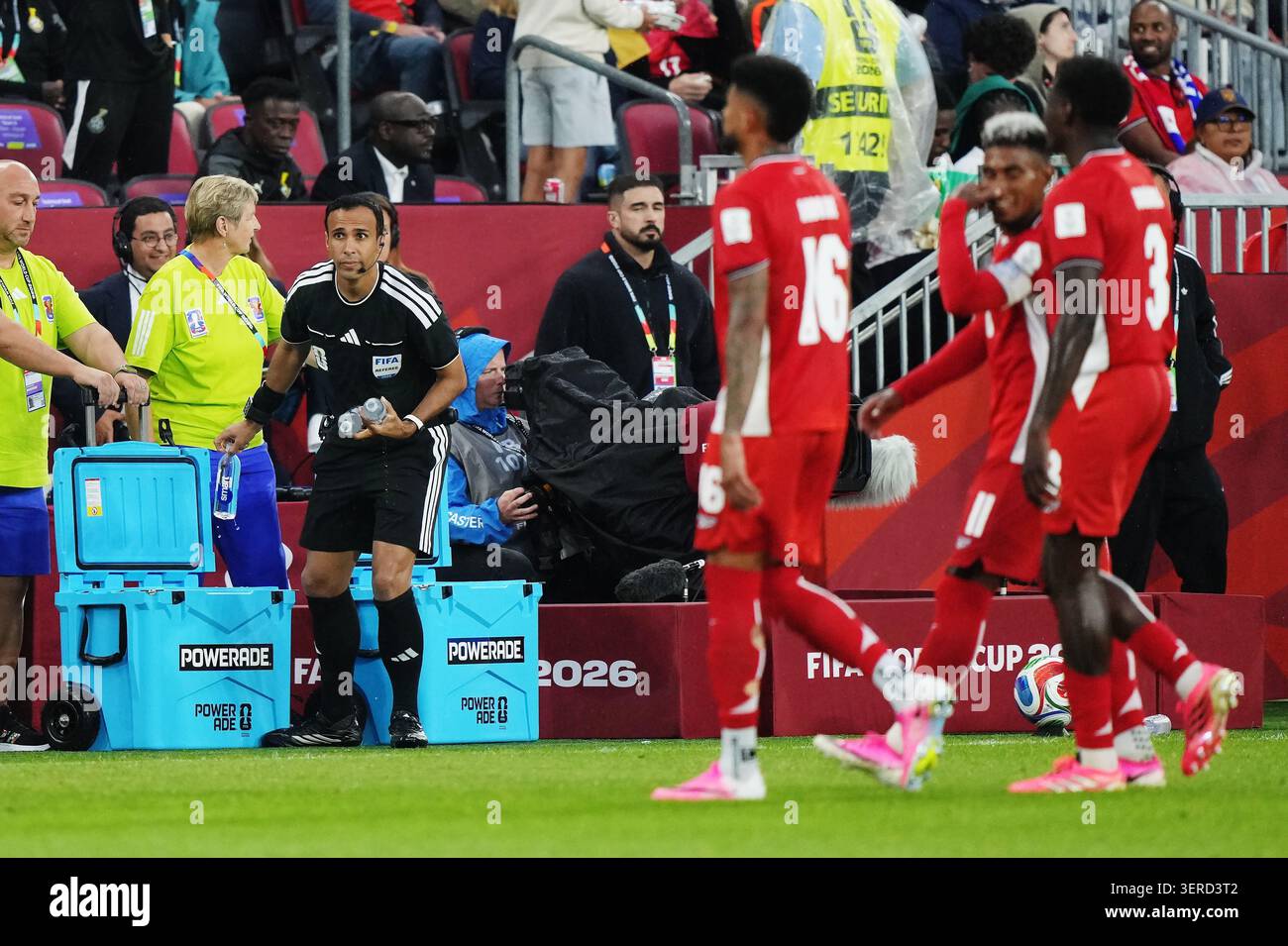 Referees get water during a hydration break in the second half of a ...