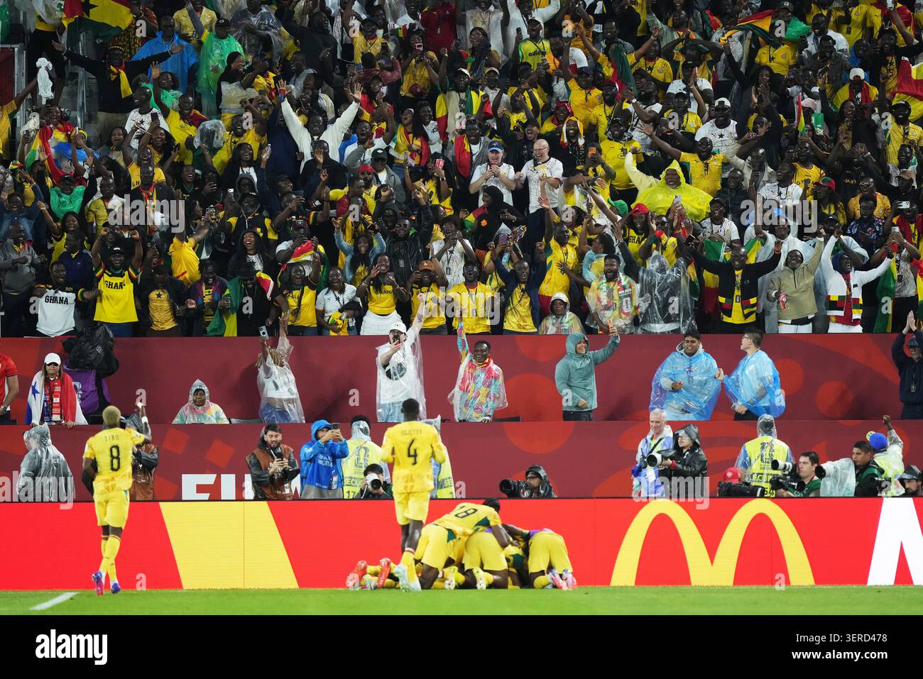 Fans celebrate as Ghana players fall on goal-scorer Caleb Yirenkyi ...