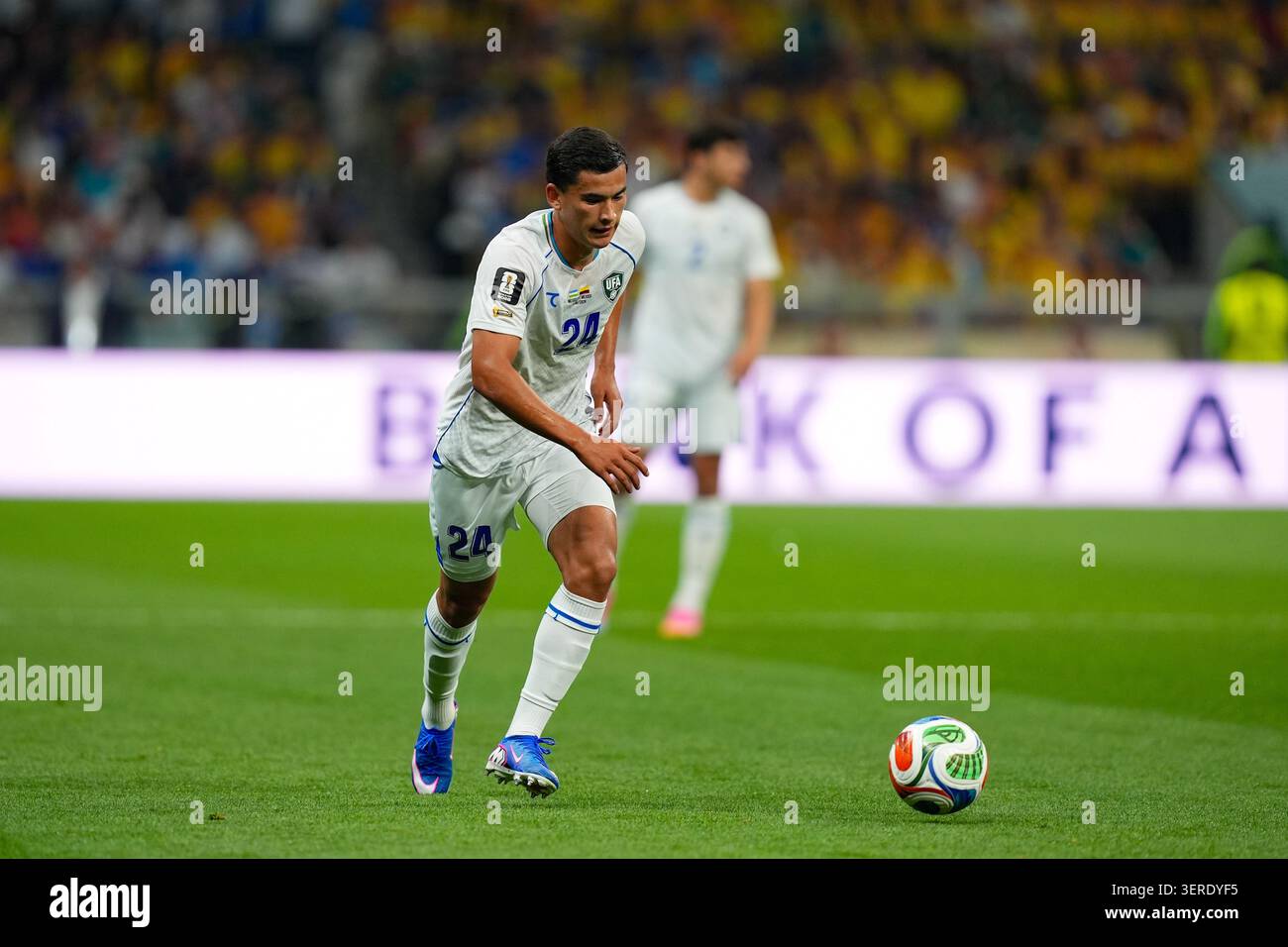 Behruzjon Karimov #24 of Uzbekistan runs whit the ball during the FIFA ...