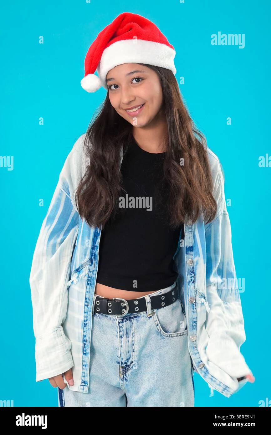 Young woman in Santa hat on blue background Stock Photo - Alamy