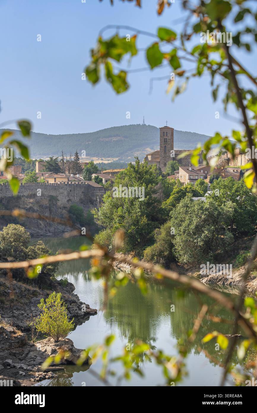 A historic stone church tower rises above medieval walls and terracotta ...