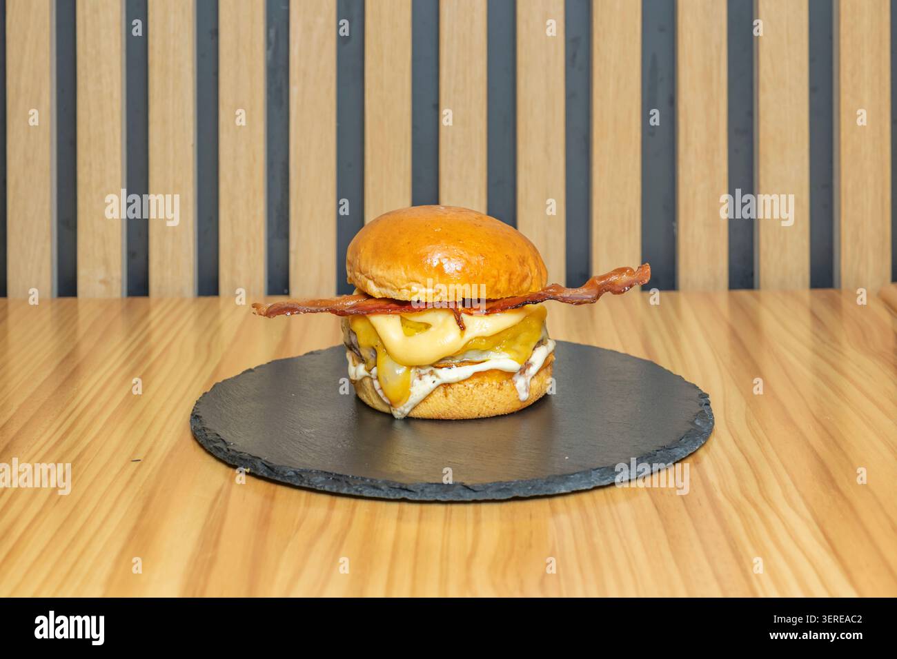 The vertical composition reveals perfect layers: a buttered potato bun ...