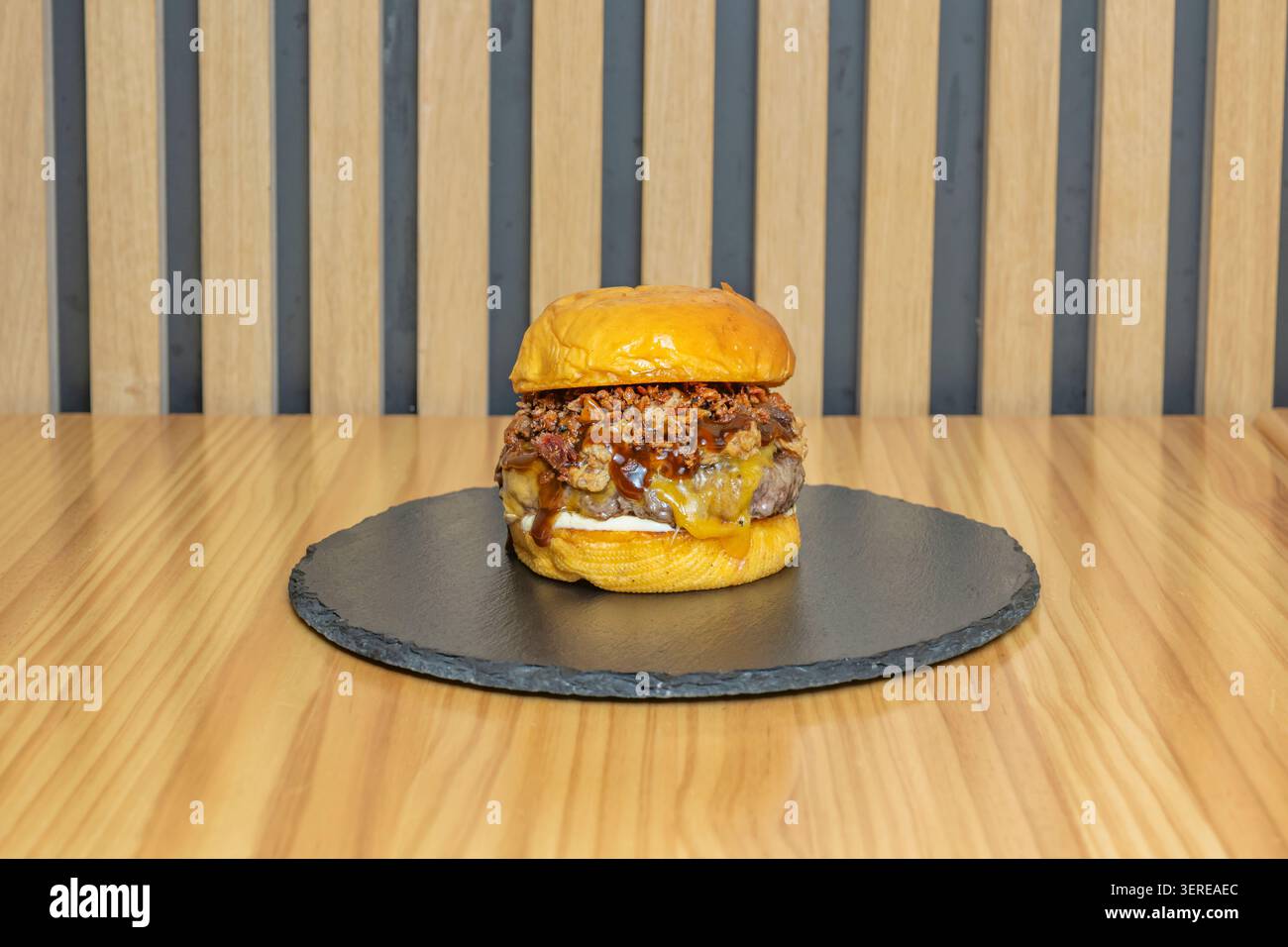 A close-up shot at table level shows the burger freshly cut in half ...