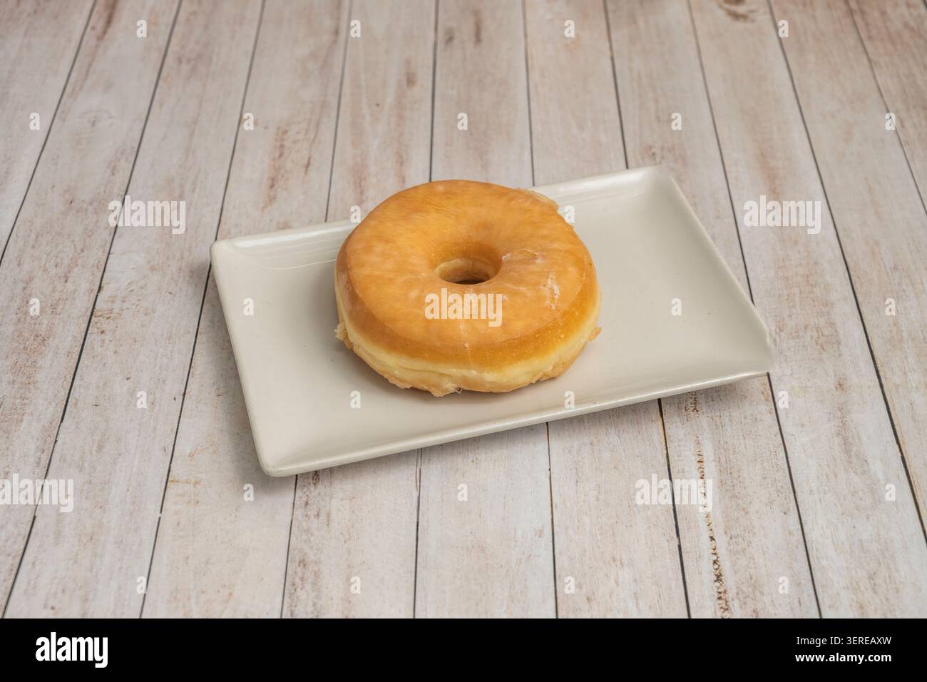 An aerial view of several rows of identical donuts, freshly glazed and ...