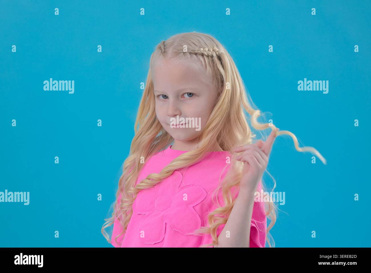 Little girl holding object on blue background Stock Photo - Alamy