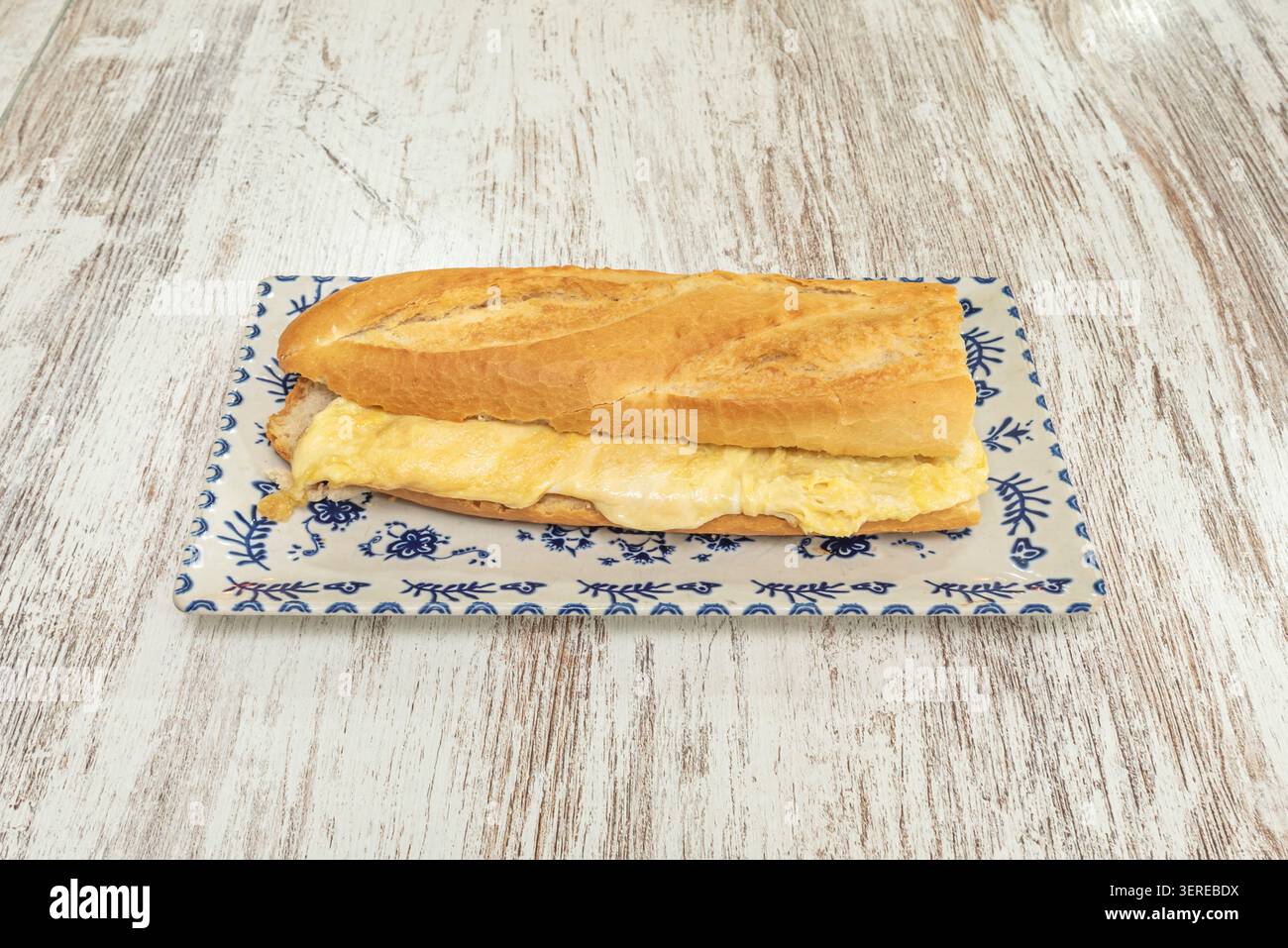 French omelette bocadillo in golden crusty bread served on a decorative ...