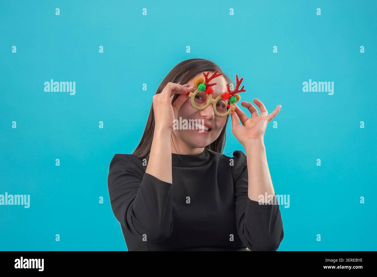 A woman looks through decorative antlers held up to her face Stock ...