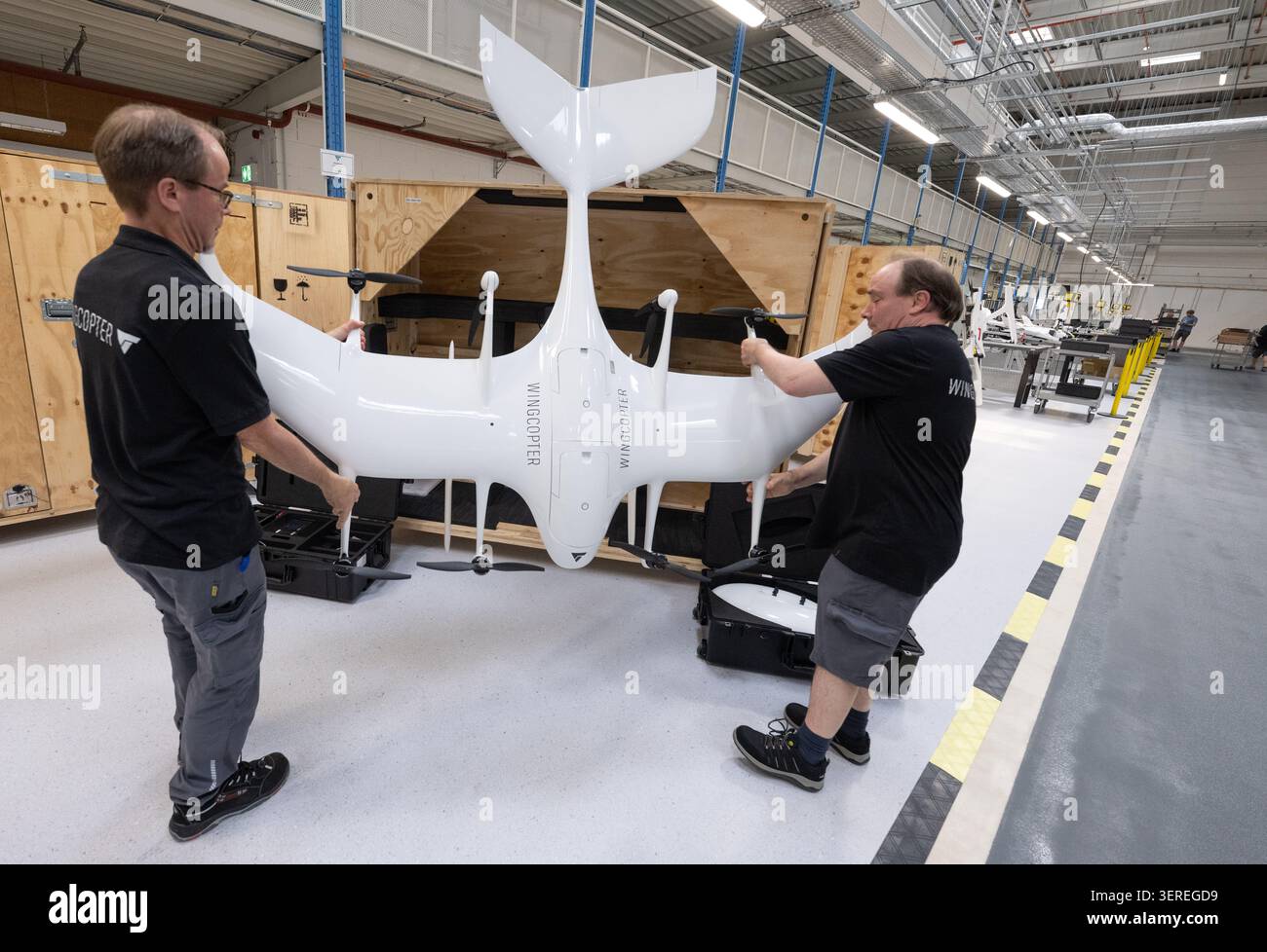 Weiterstadt, Germany. 18th June, 2026. Wingcopter employees carry a ...