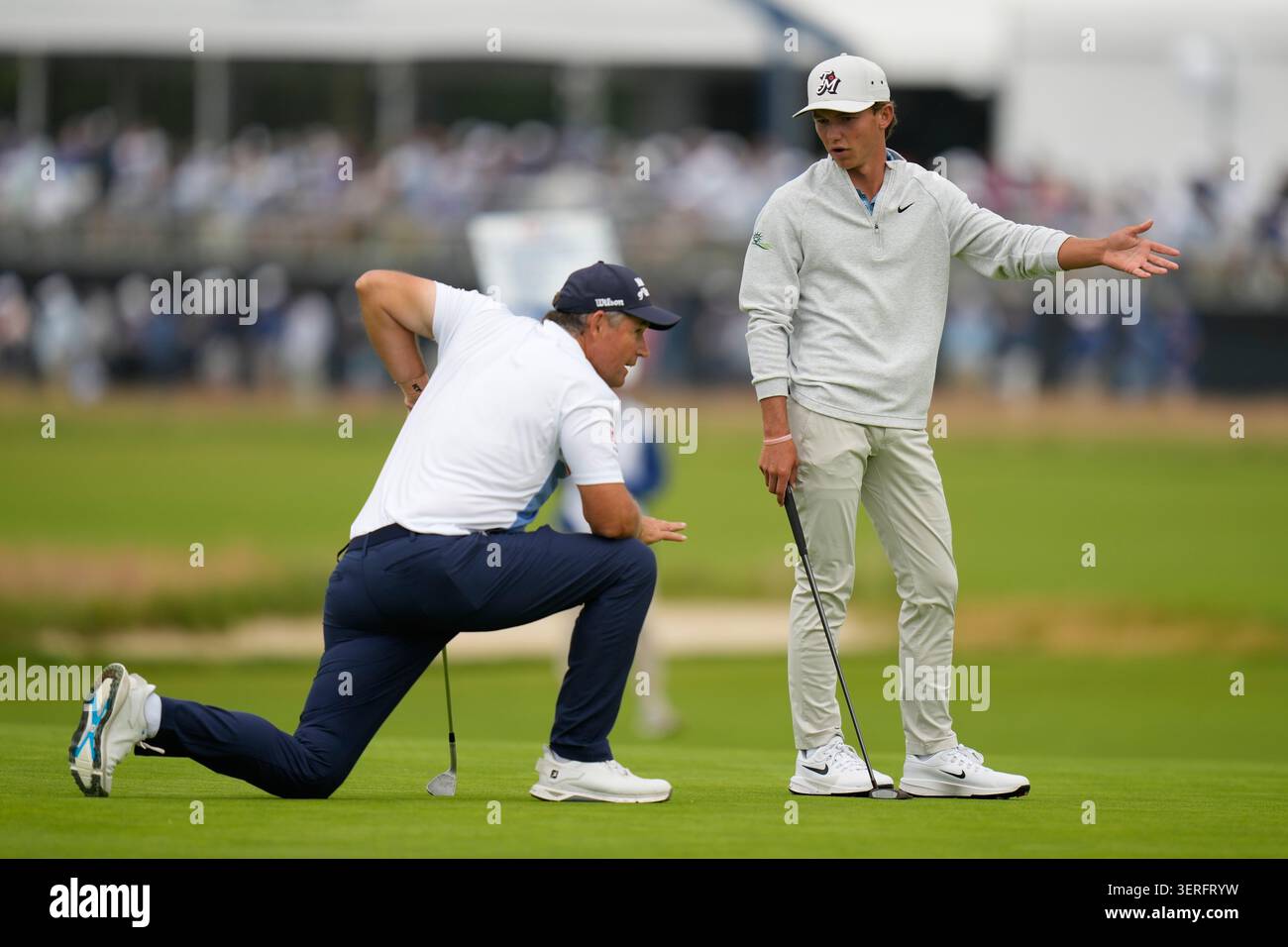 Miles Russell and Padraig Harrington, of Ireland, talk on the fourth ...