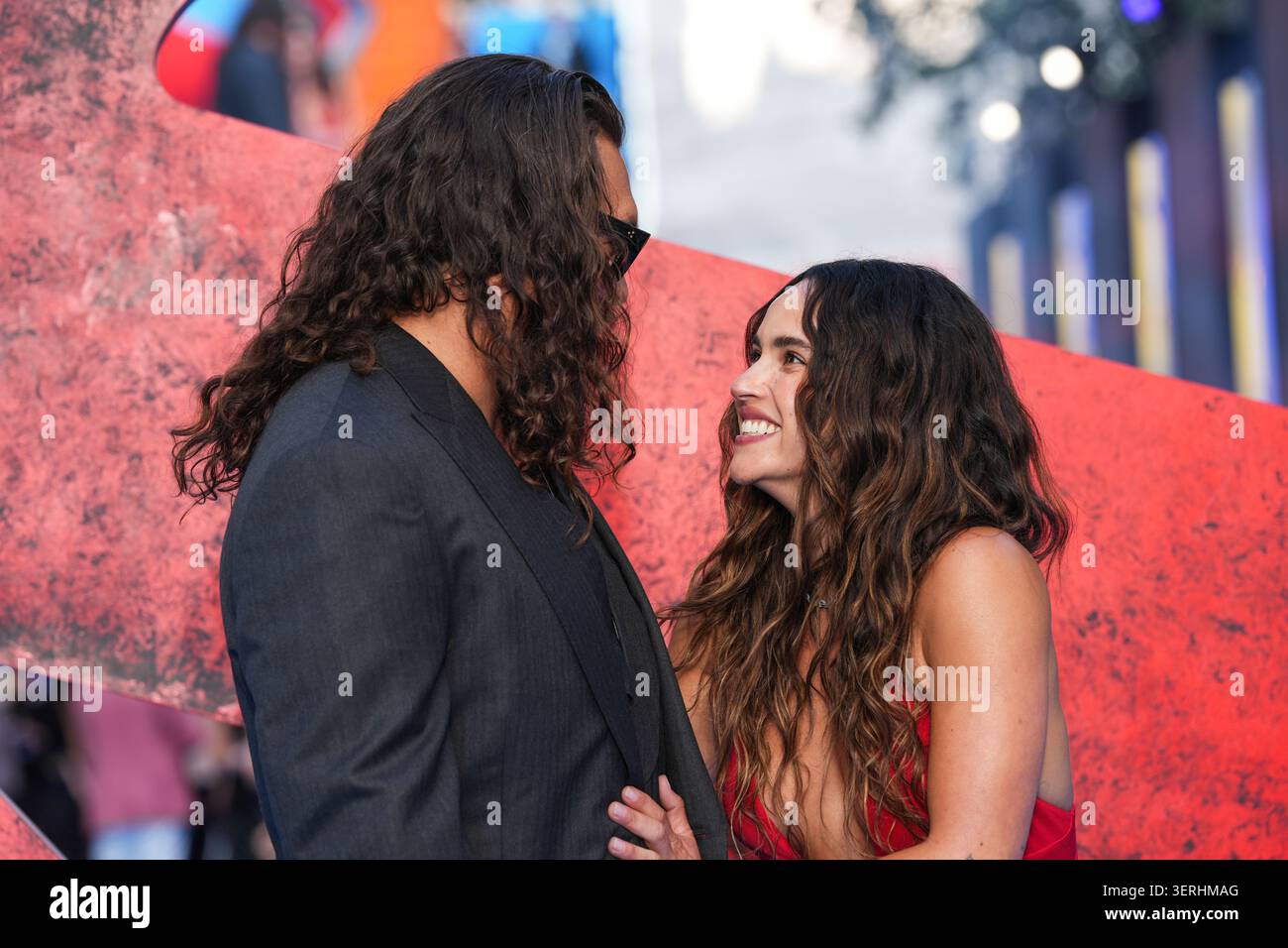 Jason Momoa, left, and Adria Arjona pose for photographers upon arrival ...