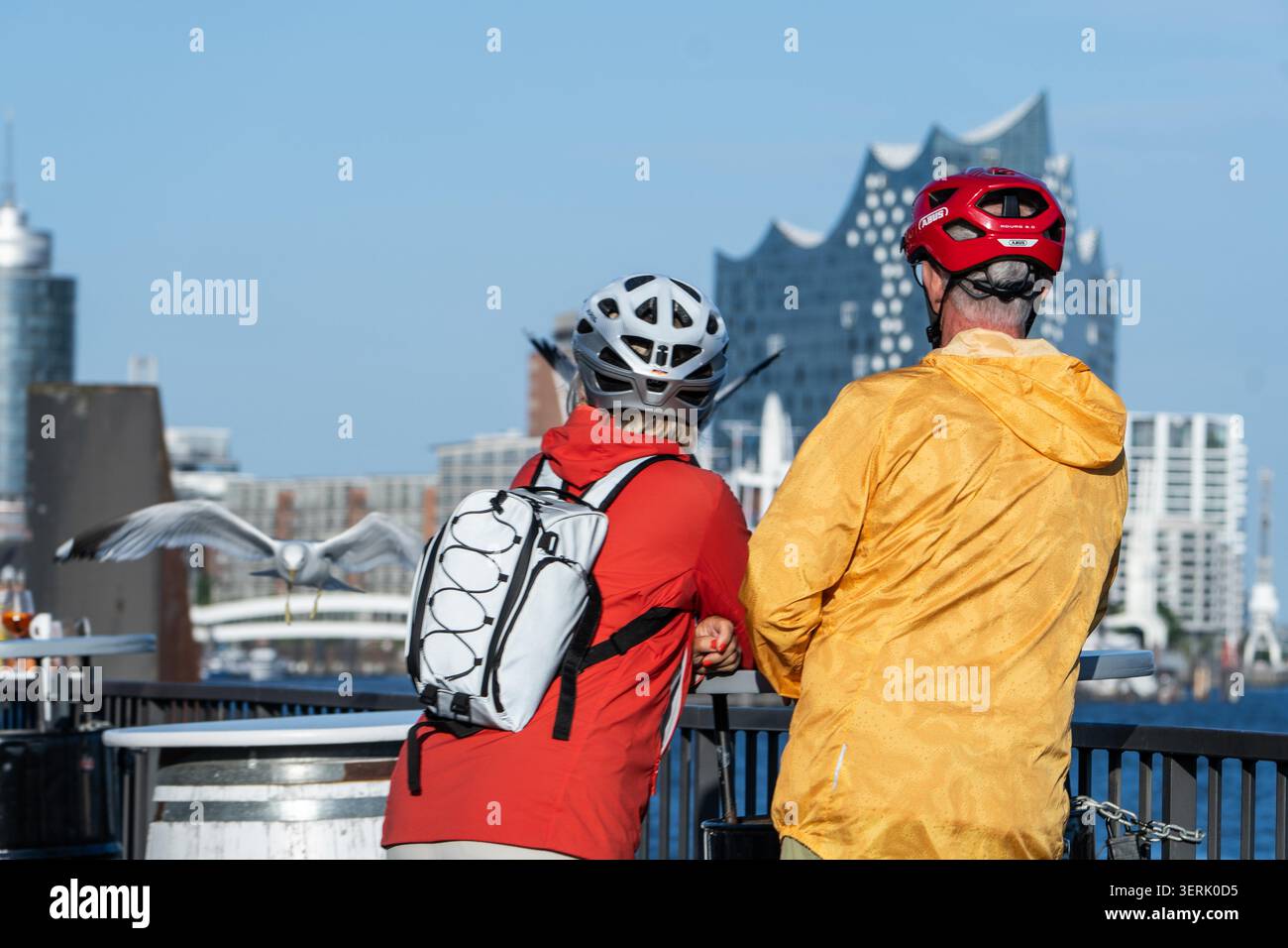 A couple with bicycle helmets stands at the Hamburg Landungsbr?cken ...