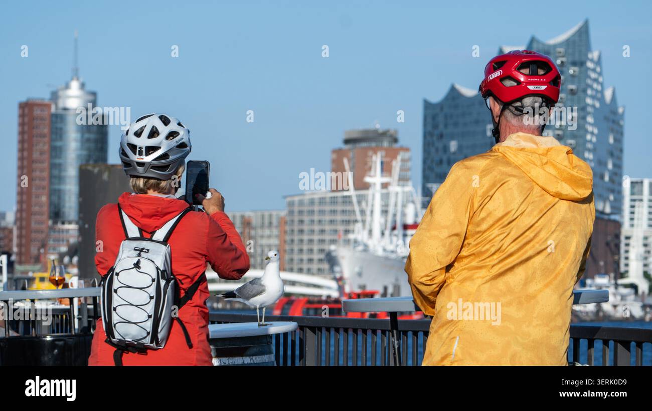 A couple with bicycle helmets stands at the Hamburg Landungsbr?cken ...