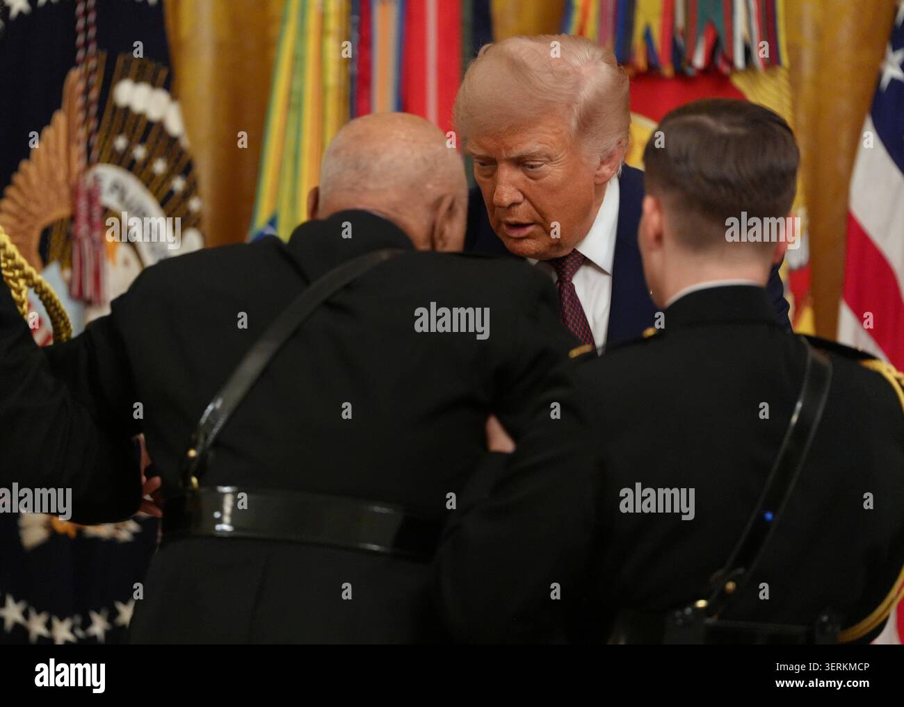 President Donald Trump, center, assists retired Marine Maj. James ...