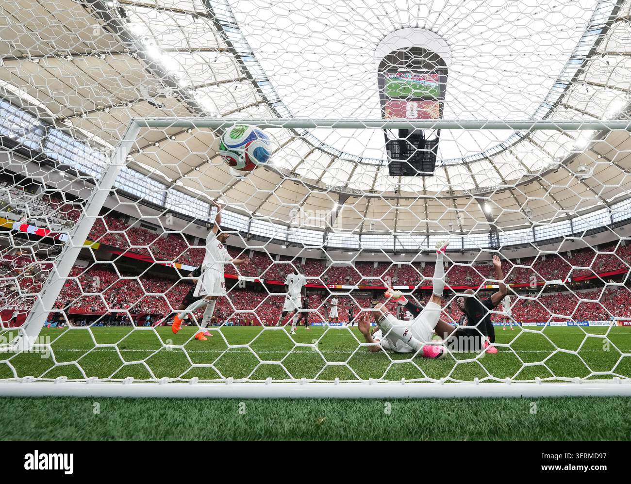 Canada's Jonathan David, back right, scores past Qatar's Boualem ...