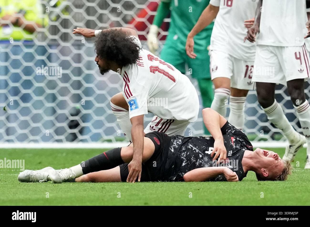 Canada's Luc de Fougerolles (4) falls as Qatar's Akram Afif (11) looks ...
