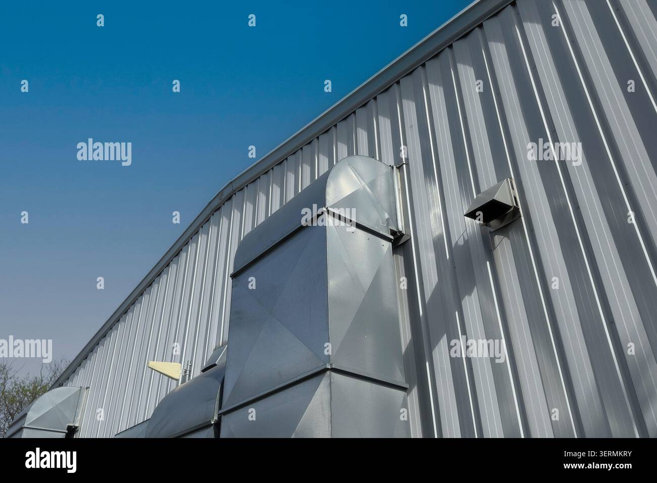 Large galvanized ventilation ducts mounted on the exterior wall of an ...