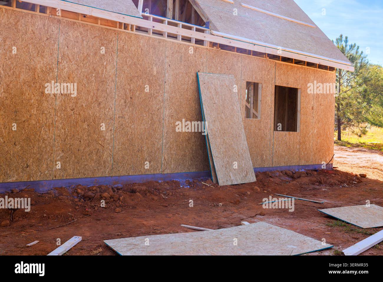 Workers are installing OSB panels on exterior of house under ...