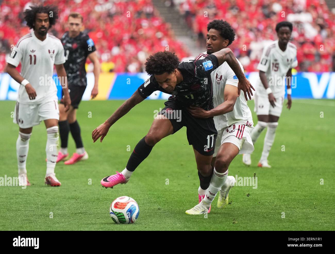 Canada's Tajon Buchanan (17) is taken down by Qatar's Akram Afif (11 ...