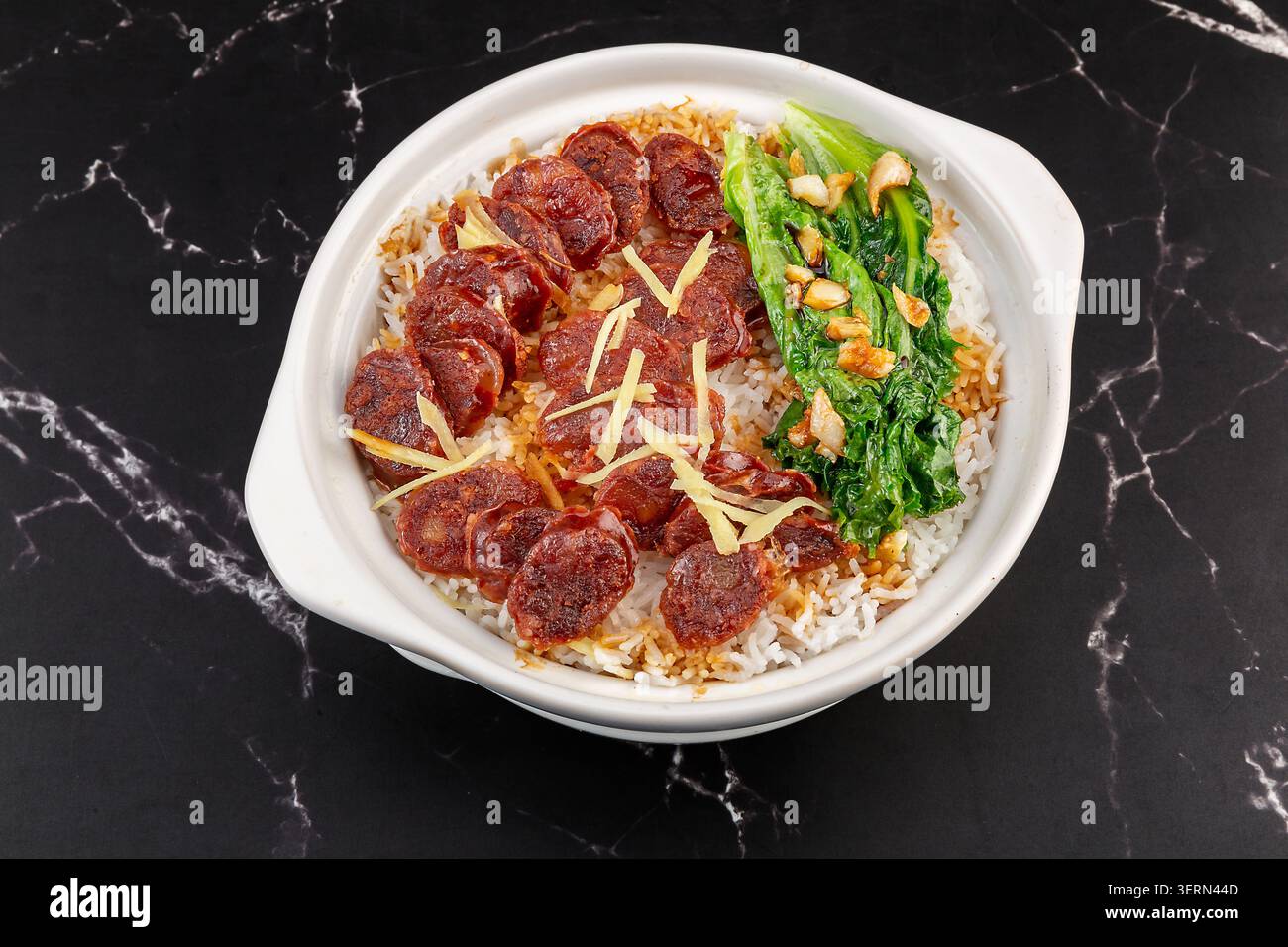 Cantonese claypot rice with sliced Chinese sausage, spoon lifting ...