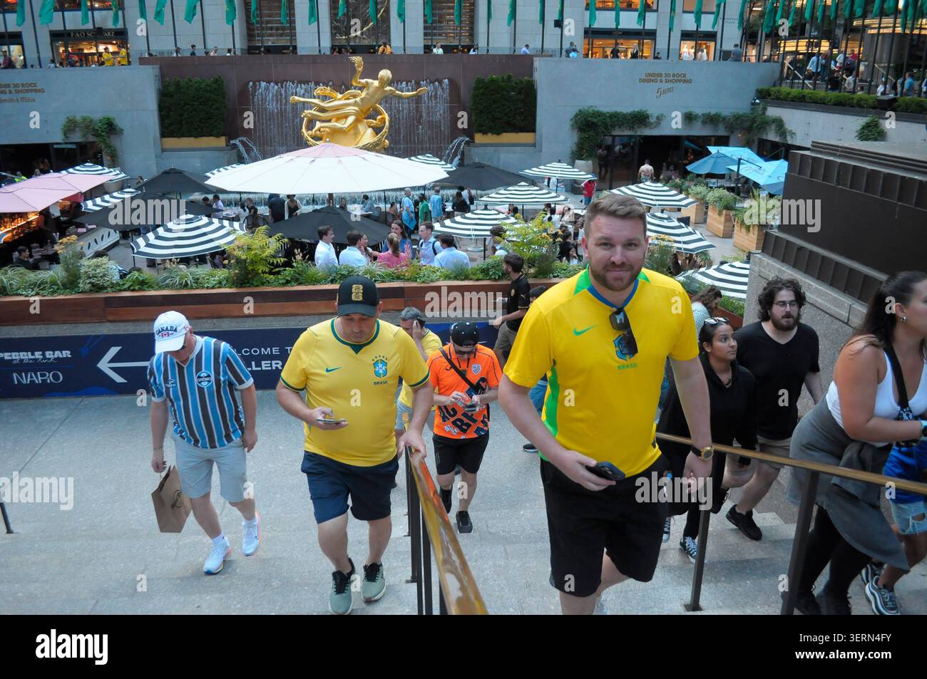 People wearing Brazilian national soccer team jerseys walk up the ...