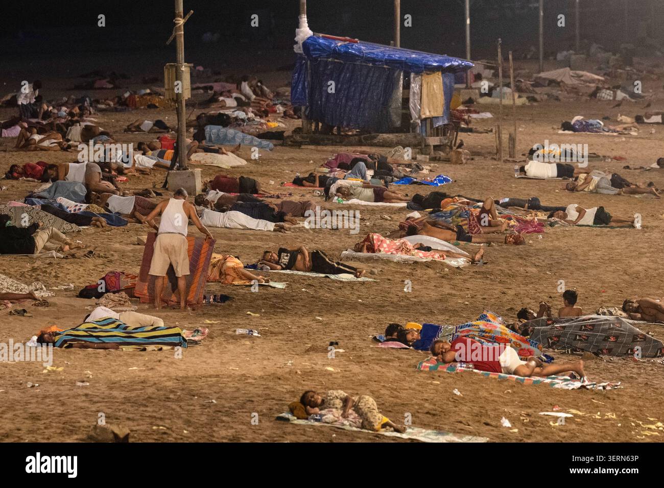 People sleep on Versova Beach to escape the oppressive indoor heat as ...