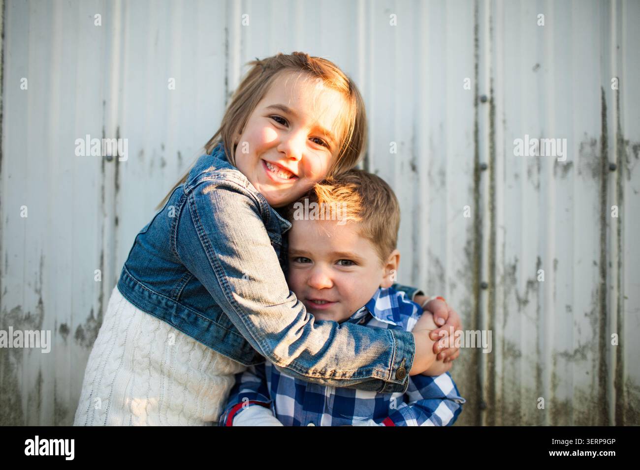 A young girl gives her younger brother a big hug Stock Photo - Alamy