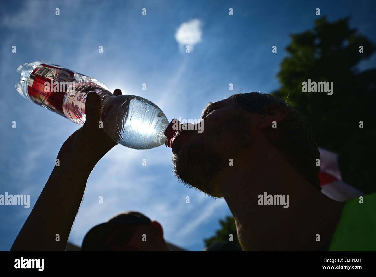19 June 2026, Berlin: A man drinks from a water bottle during a ...